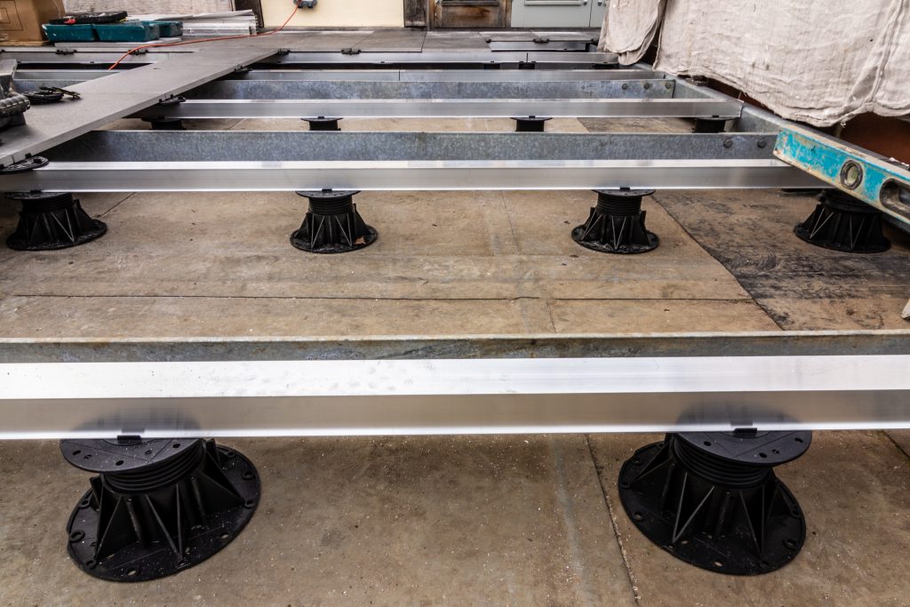 Suspended rail and pedestal system delivers complicated roof deck ...